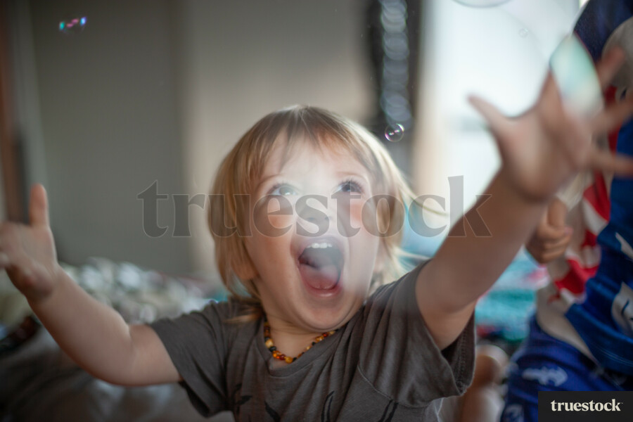 Child excited and reaching for the bubbles at home by Fraser Tebbutt ...